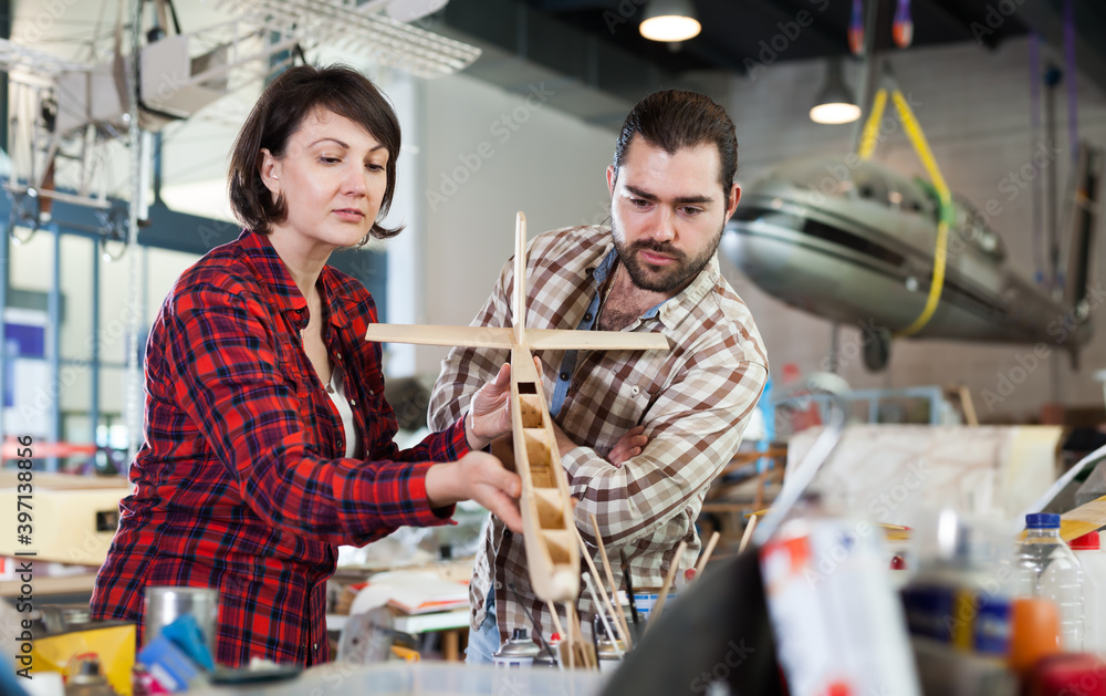 Team of aircraft enthusiasts working in workshop on creating of ...