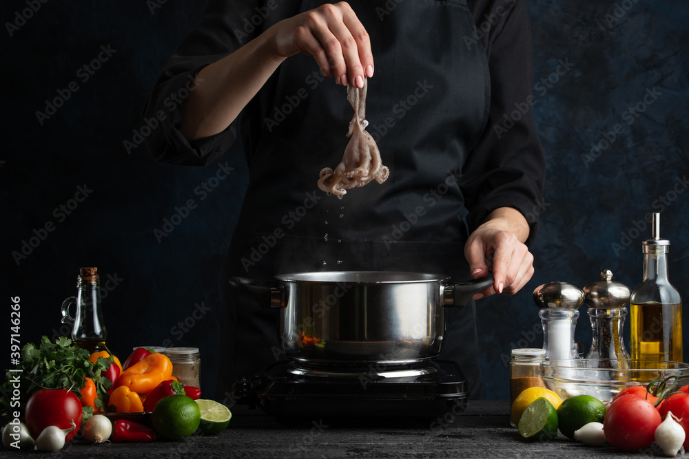Professional chef cooking traditional asian dish and puts octopus into ...
