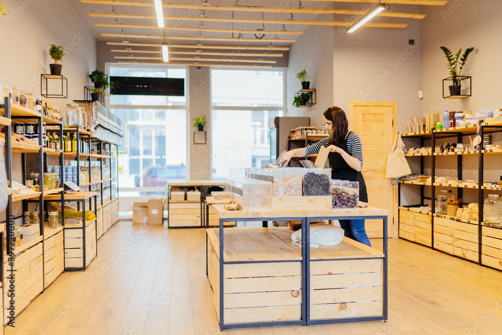Zero waste shop interior. Wooden shelves with different food goods and ...