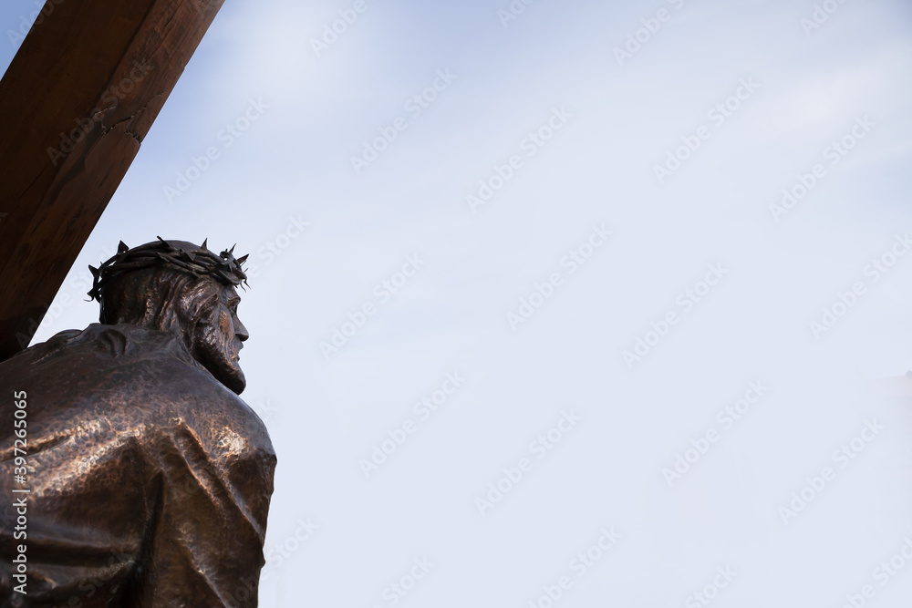 Statue of sad Jesus Cross from the back, religious background with copy ...
