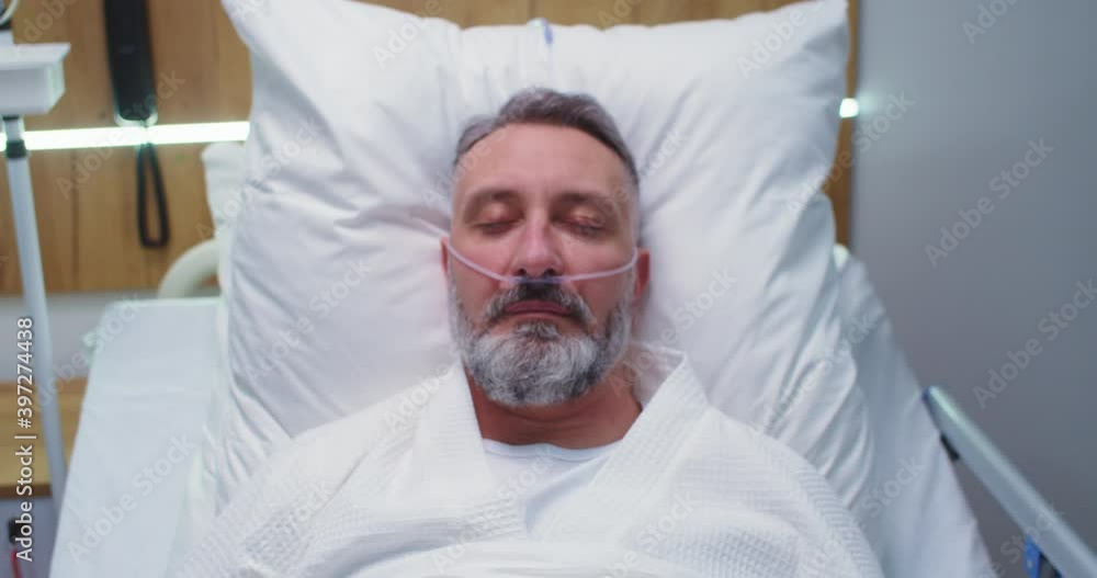 Close up portrait of Caucasian middle-aged sick male patient lying in ...