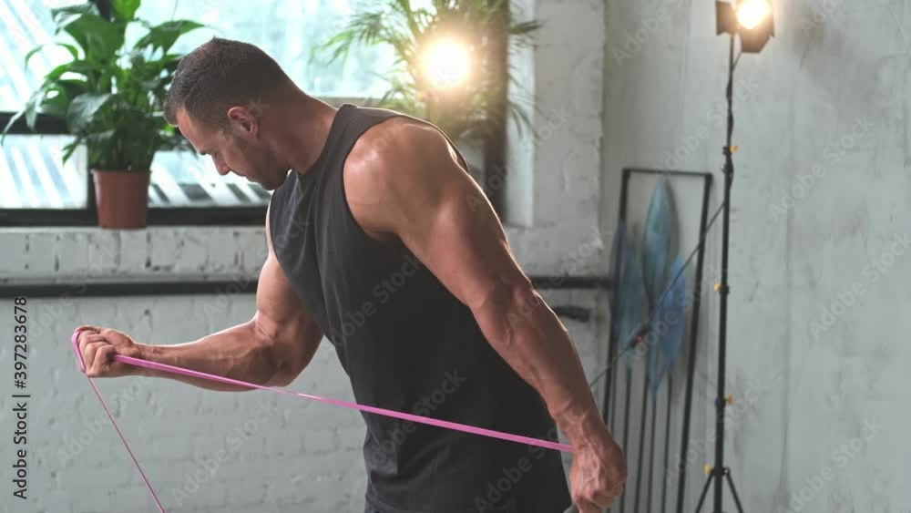 Strong and handsome bodybuilder dressed in black sportive clothing ...