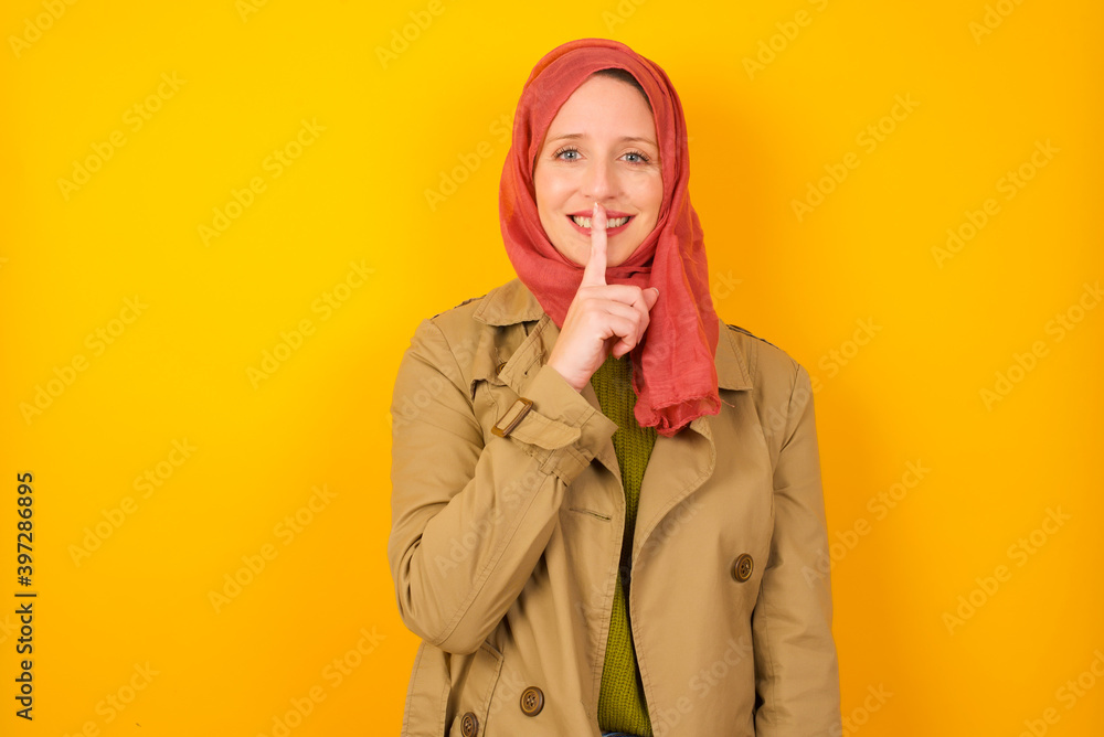 Smiling Young caucasian Muslim woman wearing hijab standing against ...