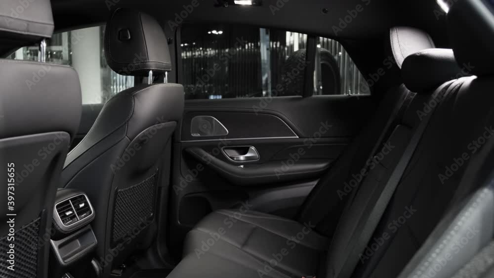 Rear seats of passengers of the new premium SUV. Black leather interior ...
