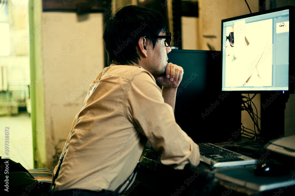 Mari man using computer at desk Stock Photo | Adobe Stock