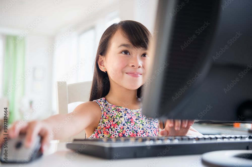 Filipino girl using computer at desk Stock Photo | Adobe Stock