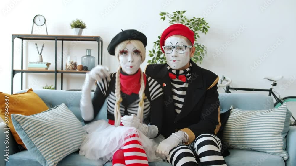Female mime is pushing guy being angry while watching TV then getting ...