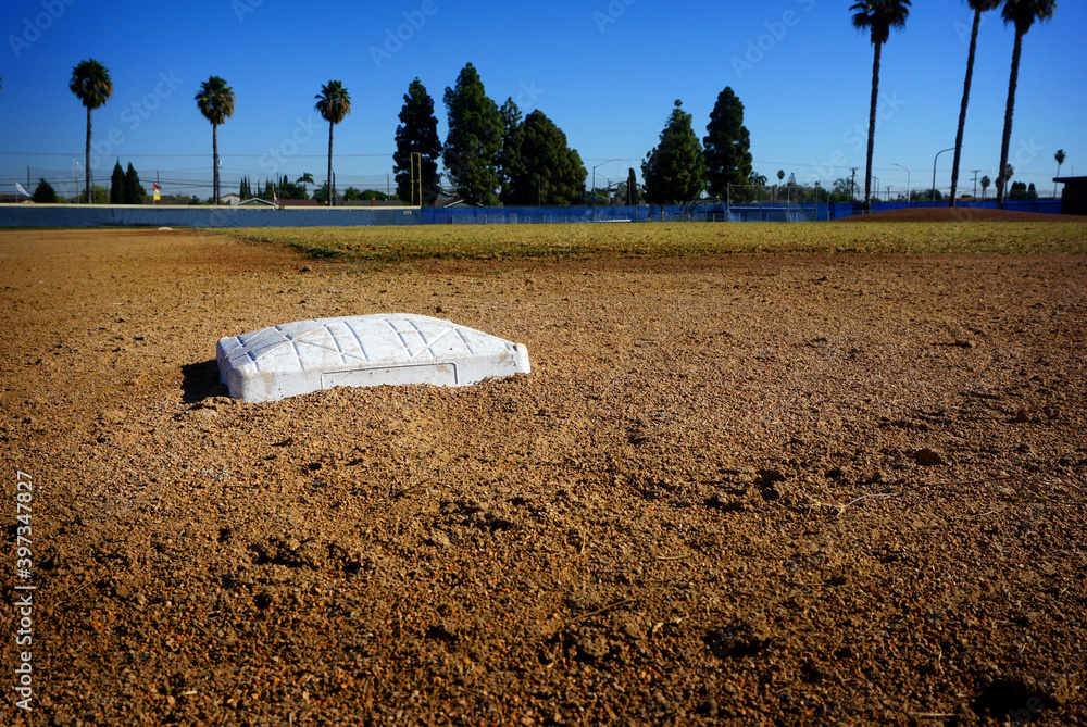 Baseball field with palm trees behind fence and base in foreground ...