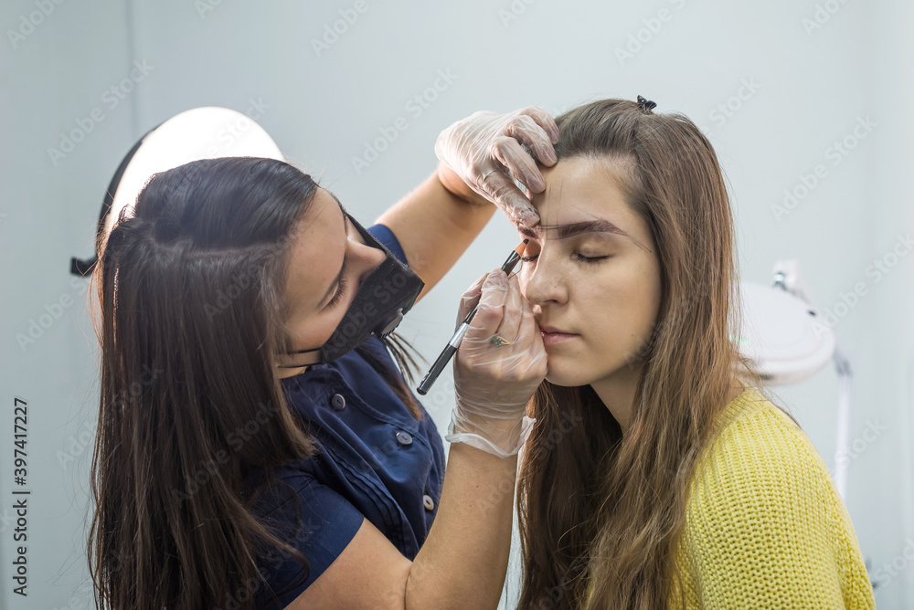 Professional facial care concept. eyebrow master draws the shape of the ...