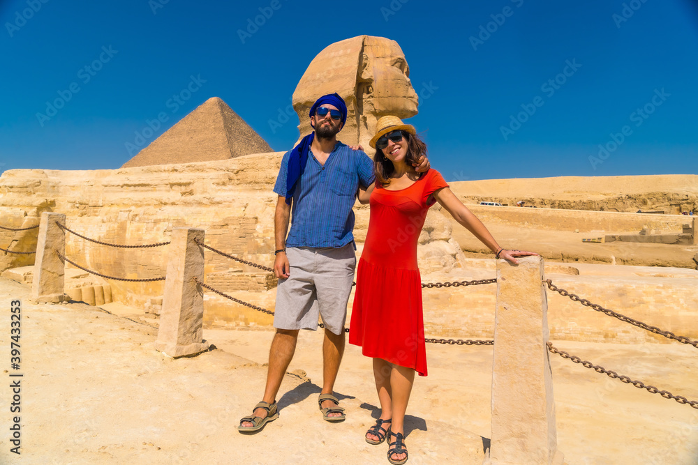 A tourist couple at The Great Sphinx of Giza and in the background the ...