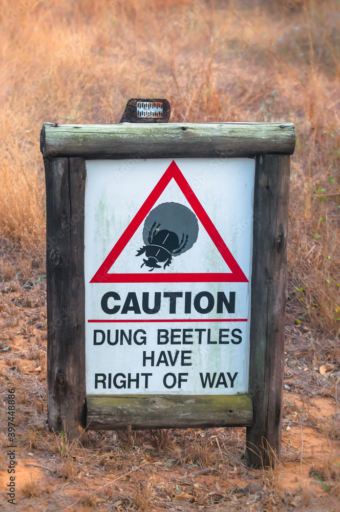 Humorous caution sign in park warning about dung beetles crossing the ...