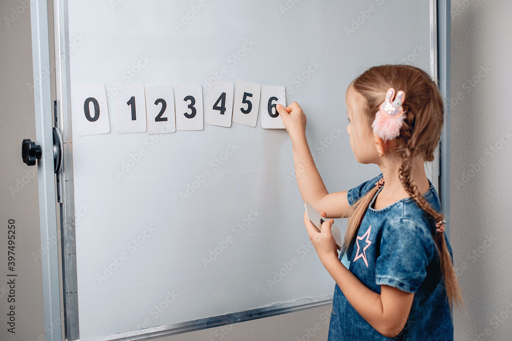 Portrait of a beautiful lovely smart kid arranging numbers in the ...