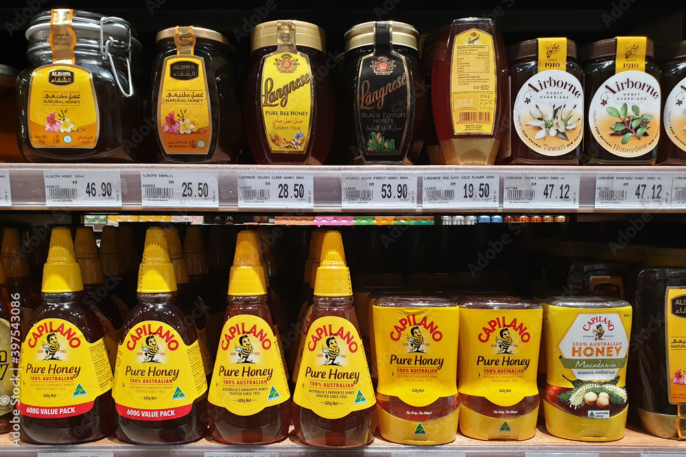Various brand imported pure honey on store shelf. Honey is a sweet ...