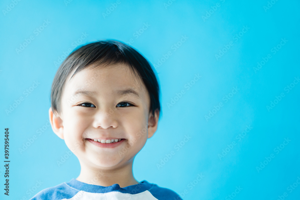 Smart asian toddler boy pointing finger on his brain blue background ...