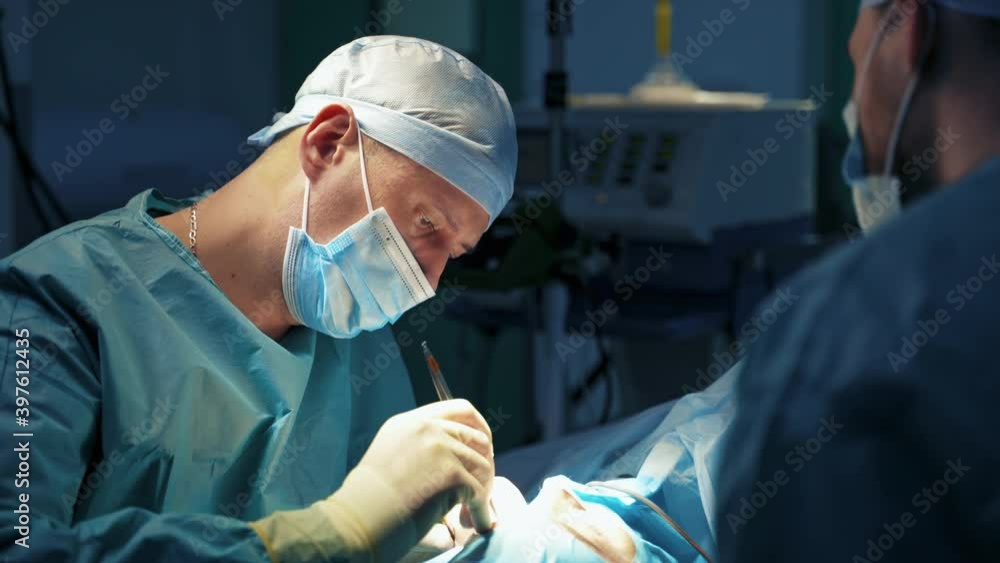 Plastic surgeons with medical equipment. Professional doctors perform a ...