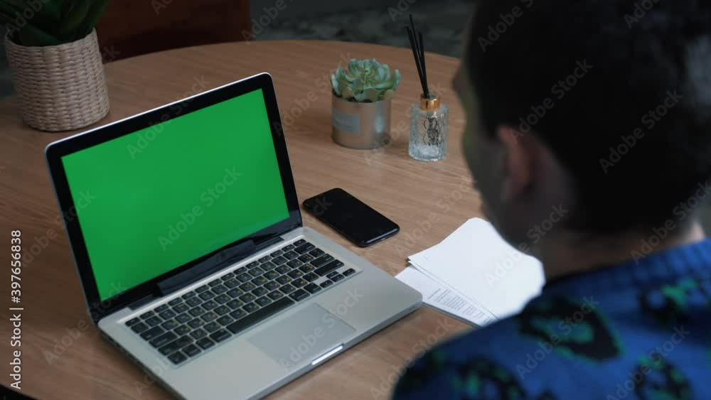 Closeup back view shot of young man having a video call on the laptop ...
