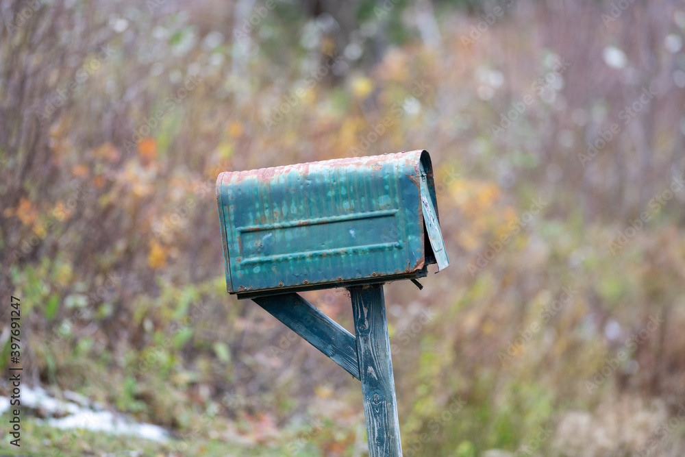 An antique country style green metal mailbox with the door open on a ...