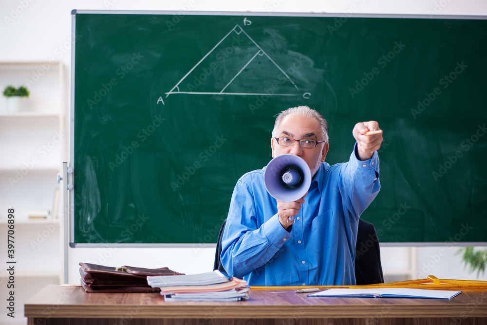 Angry aged male math teacher holding megaphone Stock Photo | Adobe Stock
