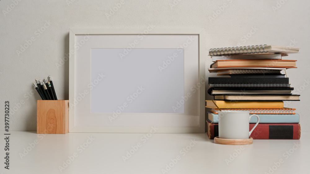 Study table with mock up frame, stack of books, pencils and copy space ...
