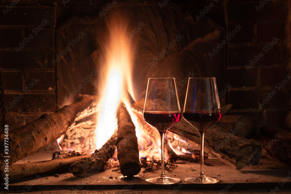 Two glasses of red wine and a lit fire Stock Photo | Adobe Stock
