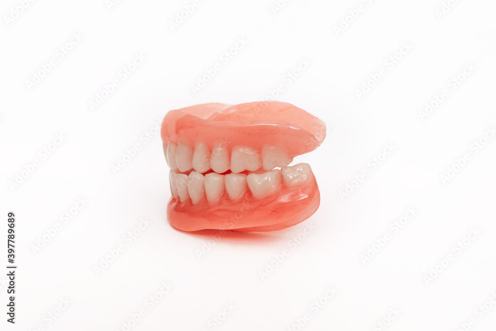 Full removable plastic denture of the jaws. Set of dentures on a white ...