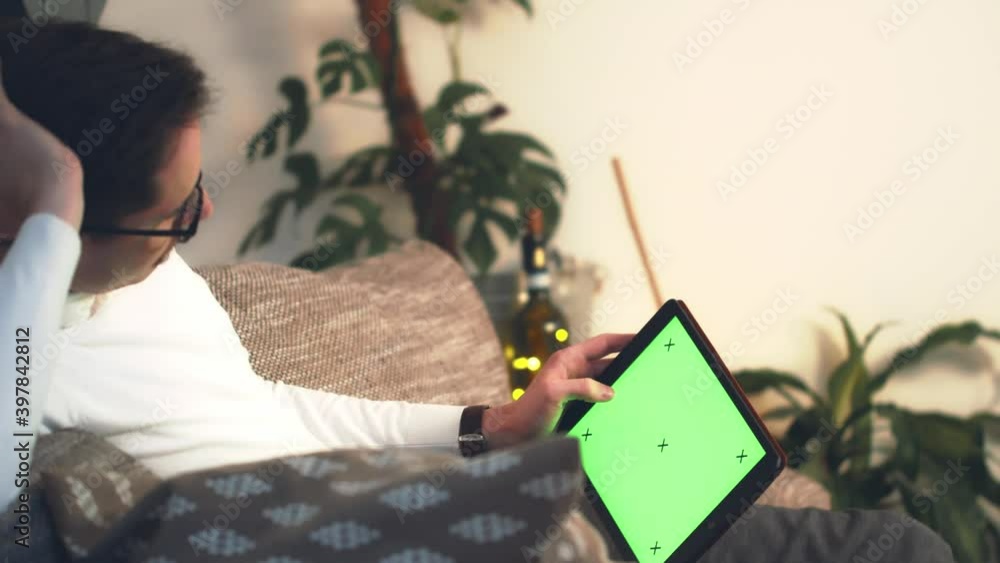 Vidéo Stock Close up of man lying down on sofa watching digital tablet with chroma key during ...