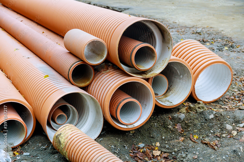 Plastic PVC pipes stacked in rows at a construction site on ...