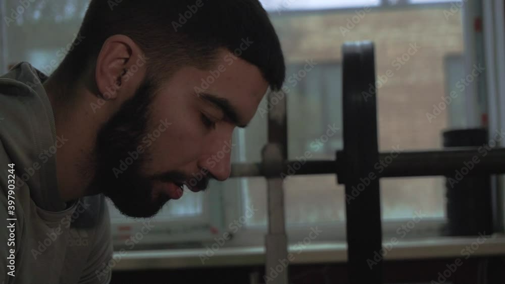 Close-up on the face of a weak, thin guy with a beard in white clothes ...