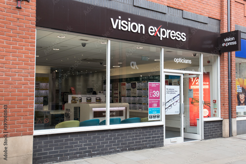 Entrance to Vision Express Opticians store shop showing logo, sign ...