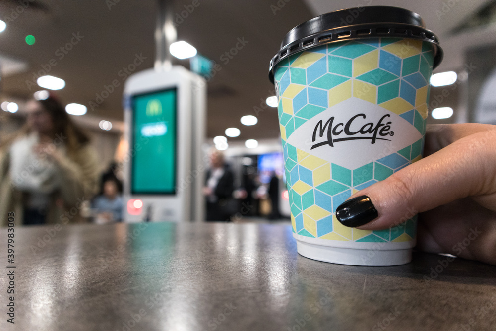 Hand holding a hot drink cup with McCafe branding inside a McDonalds ...