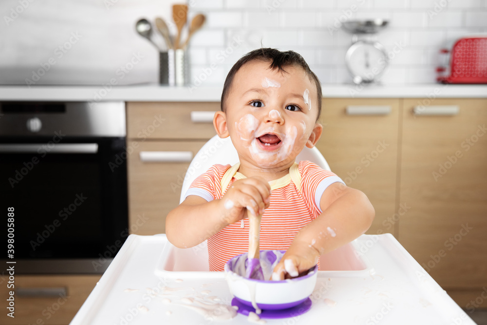 Cute baby with messy face eating yogurt Stock Photo | Adobe Stock