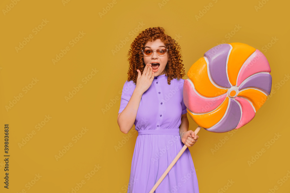 Wow, this is the world of big sugary lollipops. Funny curly young woman ...