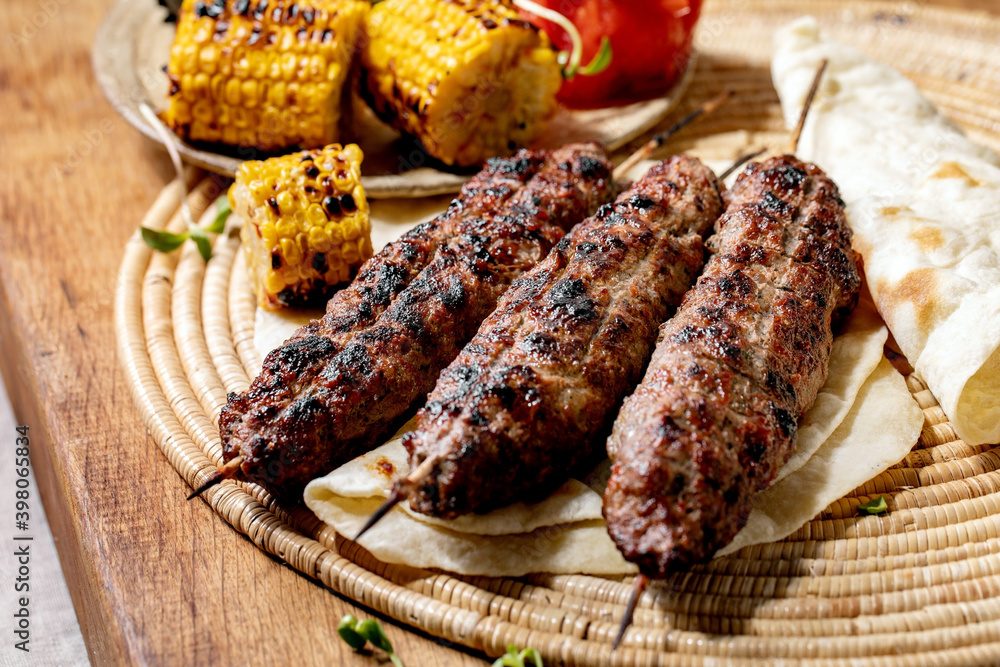 Eastern fast food. Grilled spicy beef lyulya kebab on sticks on flat ...