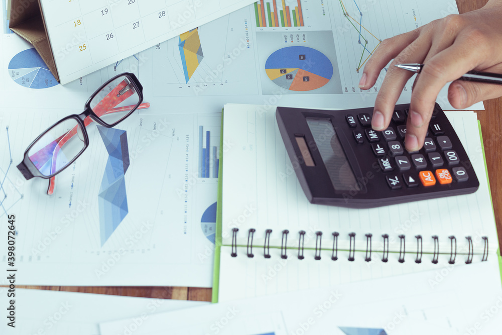 business people who use a calculator with financial concepts ...