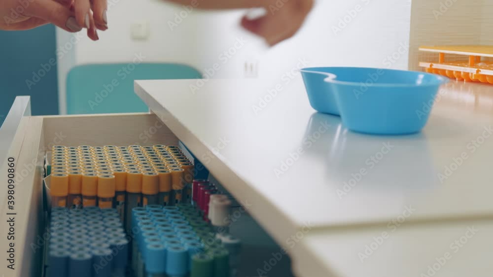 storage of blood test tubes. The lab technician opens the drawer for ...