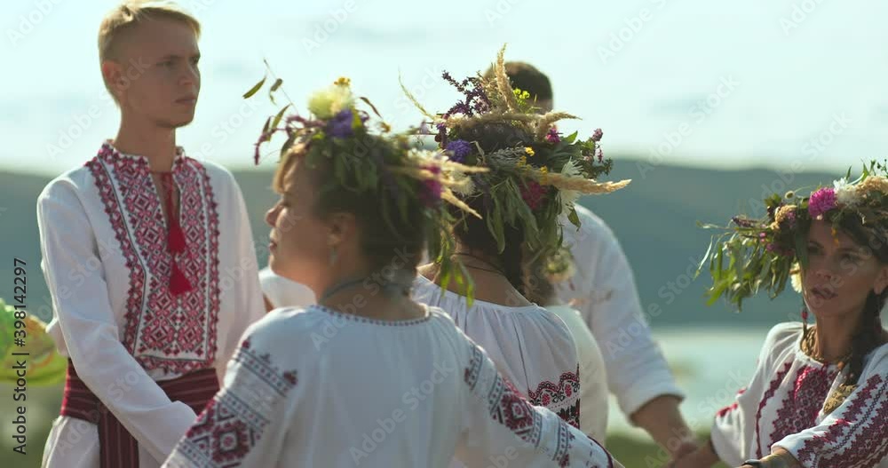 Close-up, young women in folk Slavic costumes and wreaths on their ...