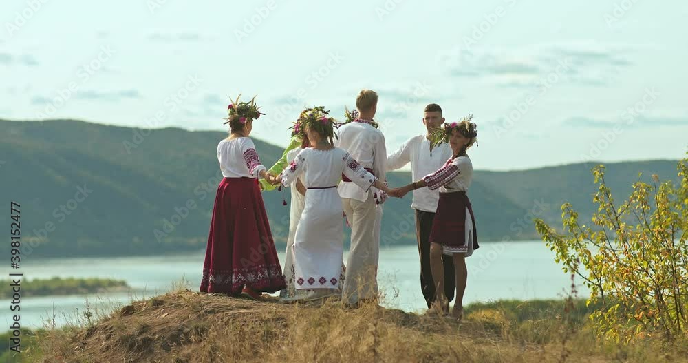Group of young people in Slavic folk costumes lead a round dance on the ...