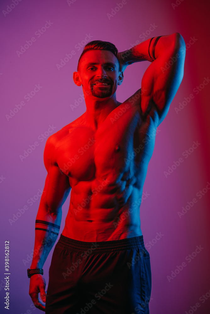 A bodybuilder with a beard is posing with a muscular arm behind his ...