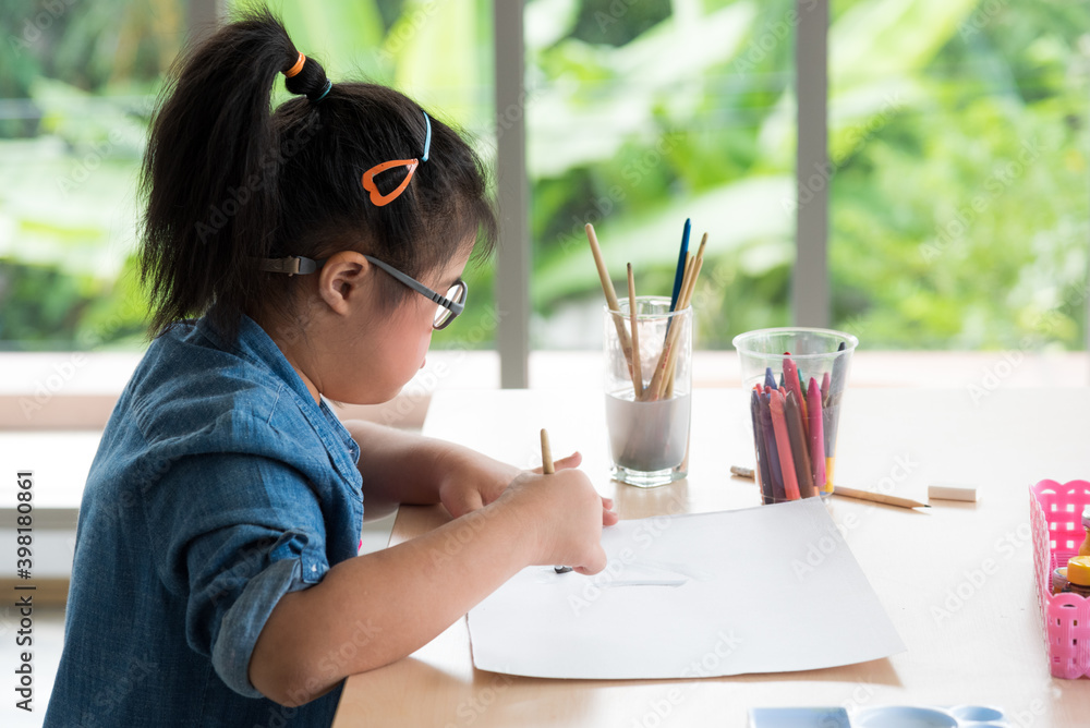Portrait of young Asian disabled child down's syndrome girl draw a ...