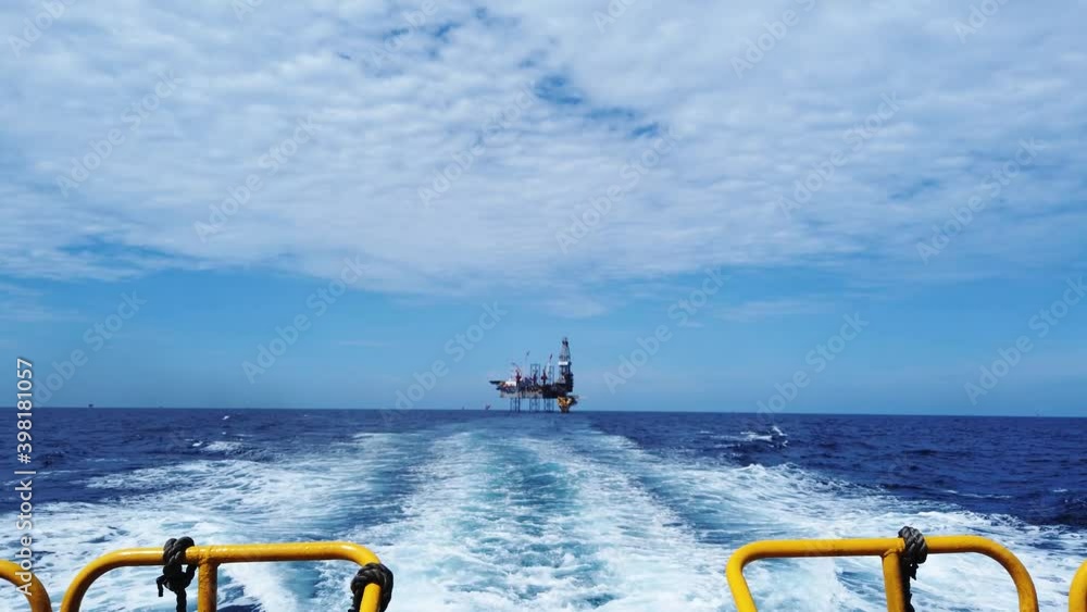 Crew boat sailing to the offshore jack up drilling rig in the middle of ...