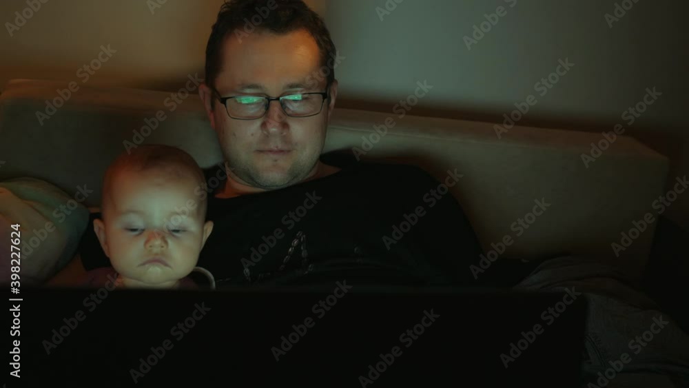 baby girl with father watching movie computer screen at night Stock ...