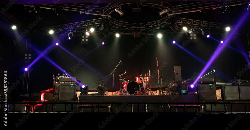 Illuminated empty blue concert stage with fog and rays of light in the ...