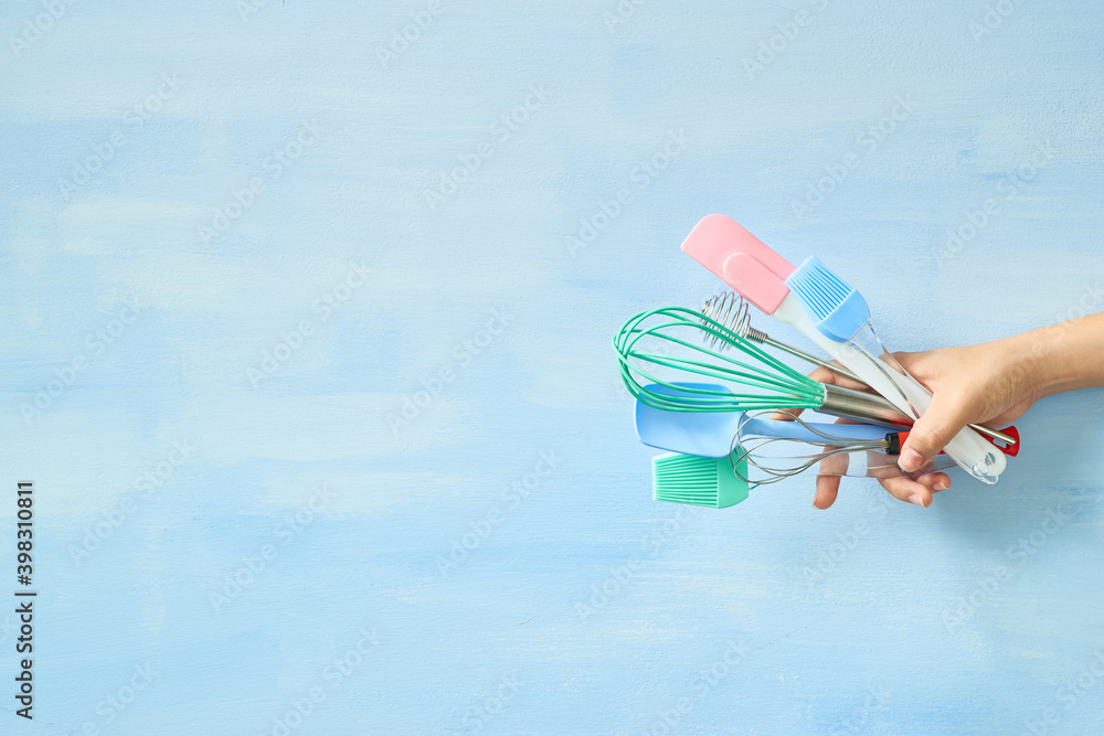 Frame with hand holding many different kitchen tools Stock Photo ...