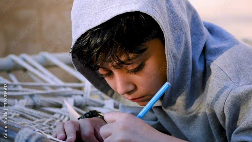 Portrait of Indian school kid drawing, sketching on page with pensile ...
