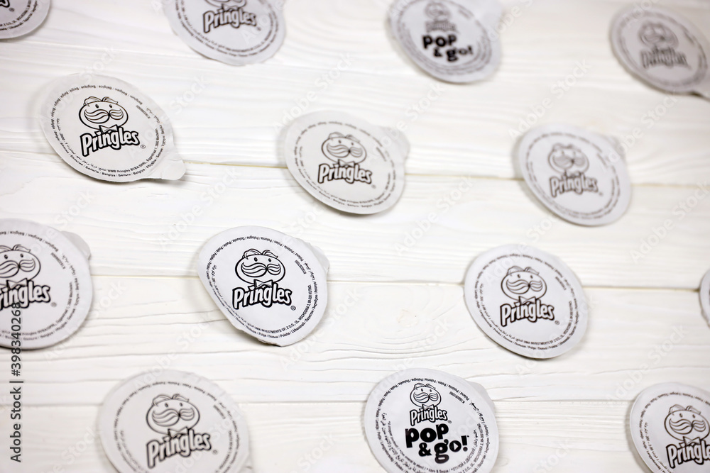 Pringles logo on paper membranes on white wooden table. Pringles is a ...