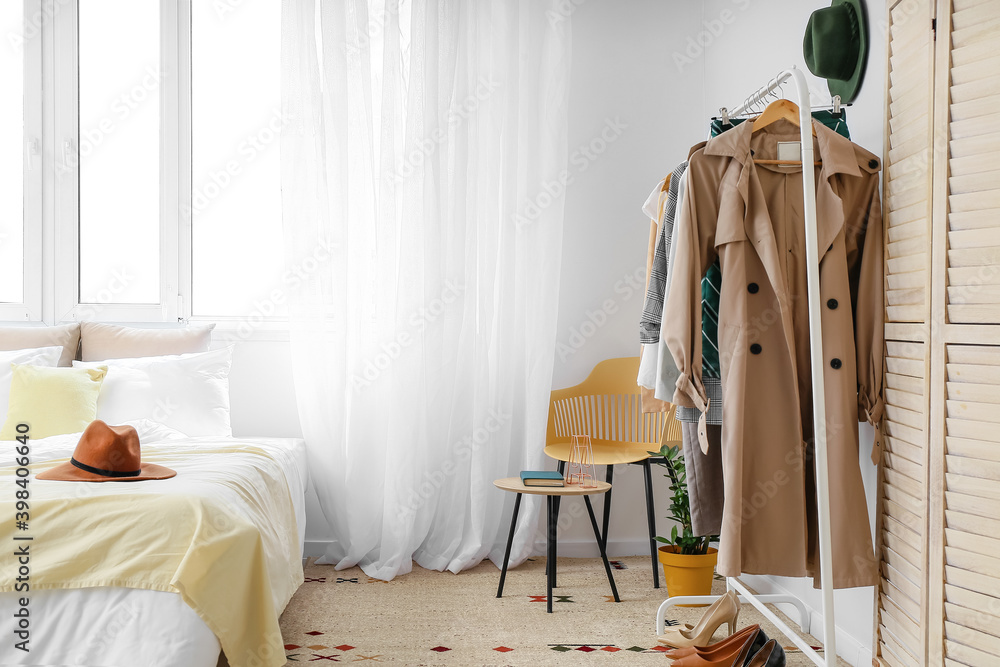Interior of stylish bedroom with clothes rack Stock Photo | Adobe Stock