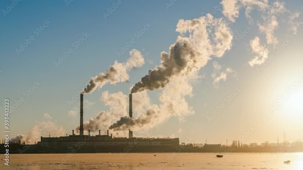 Smoke from chimney factory at sunrise. Dark outlines and silhouettes of ...