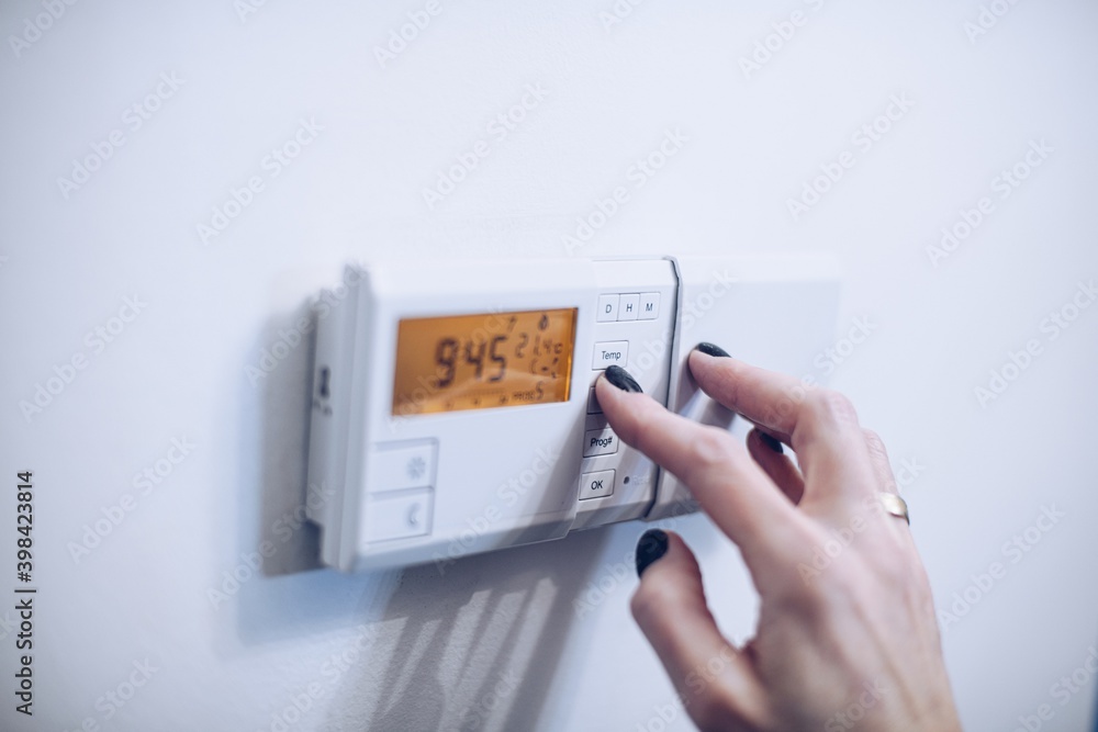 Regulating temperature on modern home heating control panel Stock Photo ...