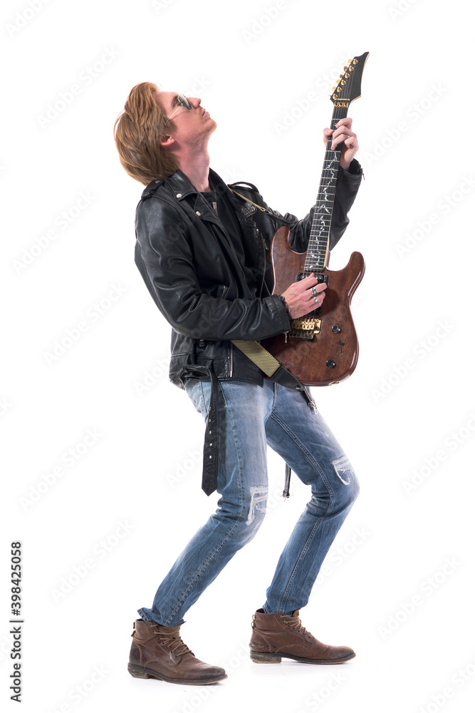 Side view of passionate skilled rock guitarist playing electric guitar ...