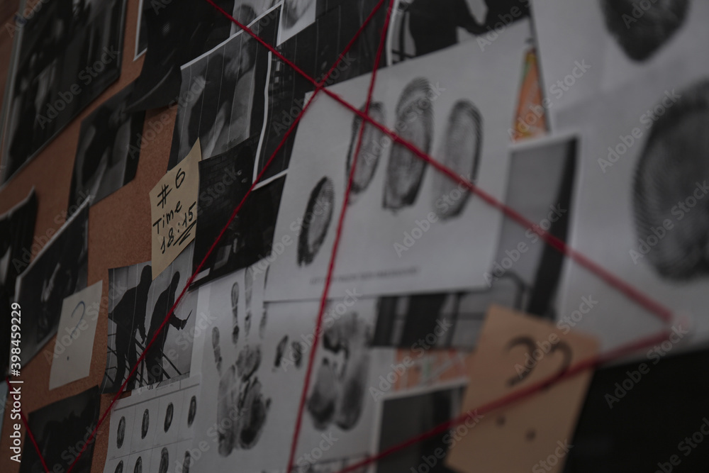 Detective board with crime scene photos, stickers, clues and red thread ...